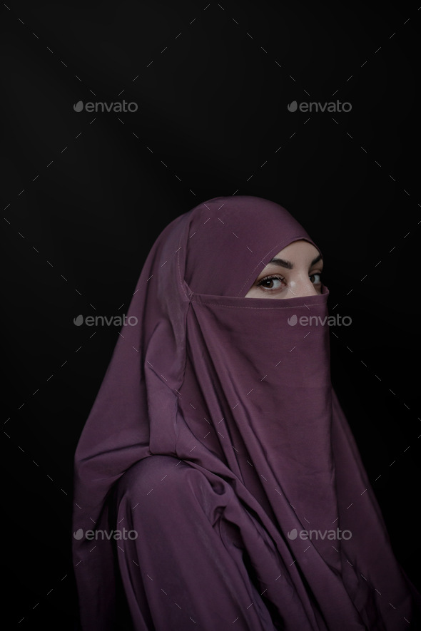 Muslim woman wearing a niqab looking at camera Stock Photo by Lemnaouer