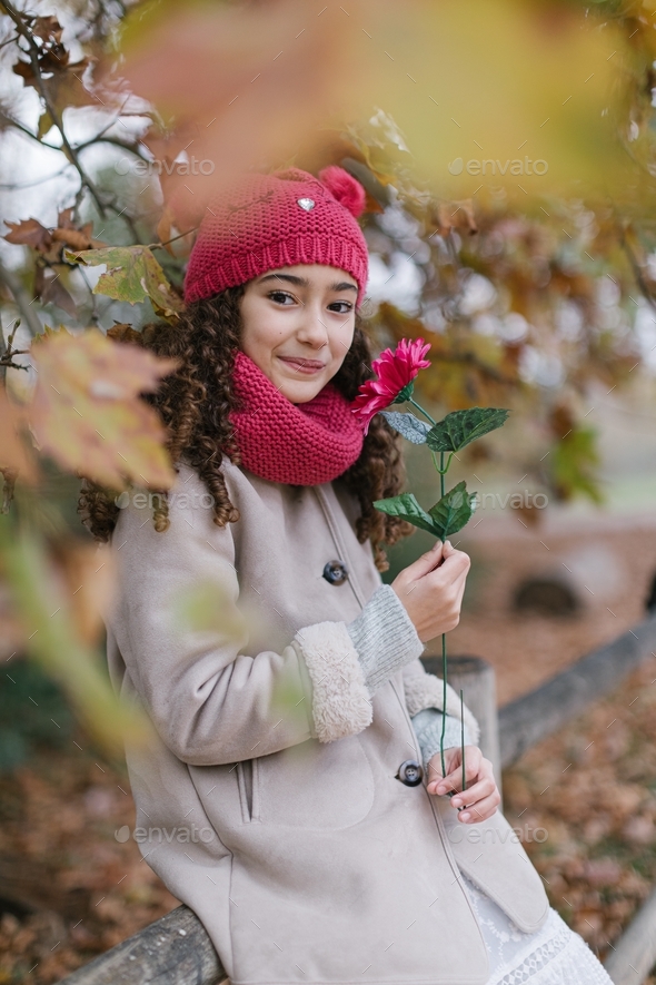 Gen z girl with curly hair sitting in the woods smiling Stock Photo by ...