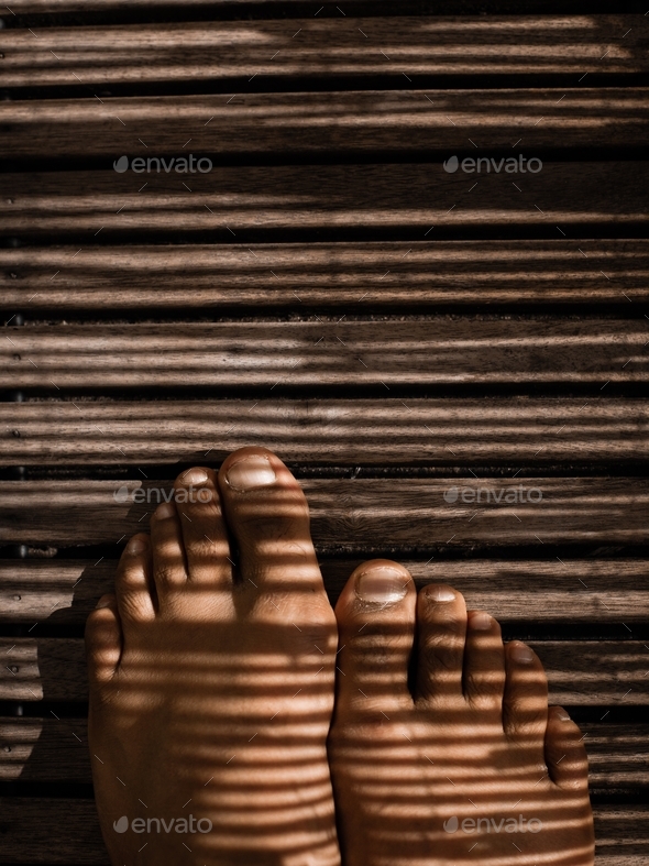 Feet of a man on in light and shadow Stock Photo by Lemnaouer | PhotoDune