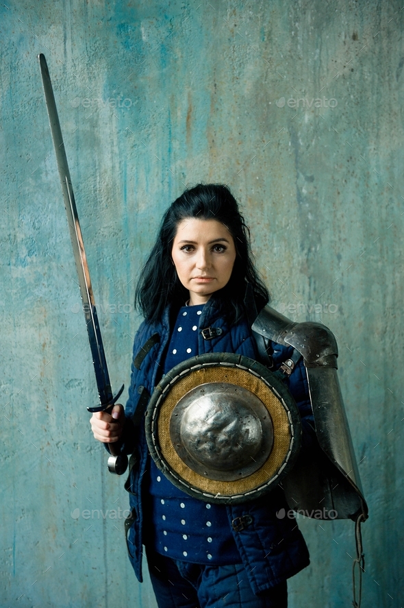 Beautiful brunette woman in ancient iron knightly armor. Medieval ...