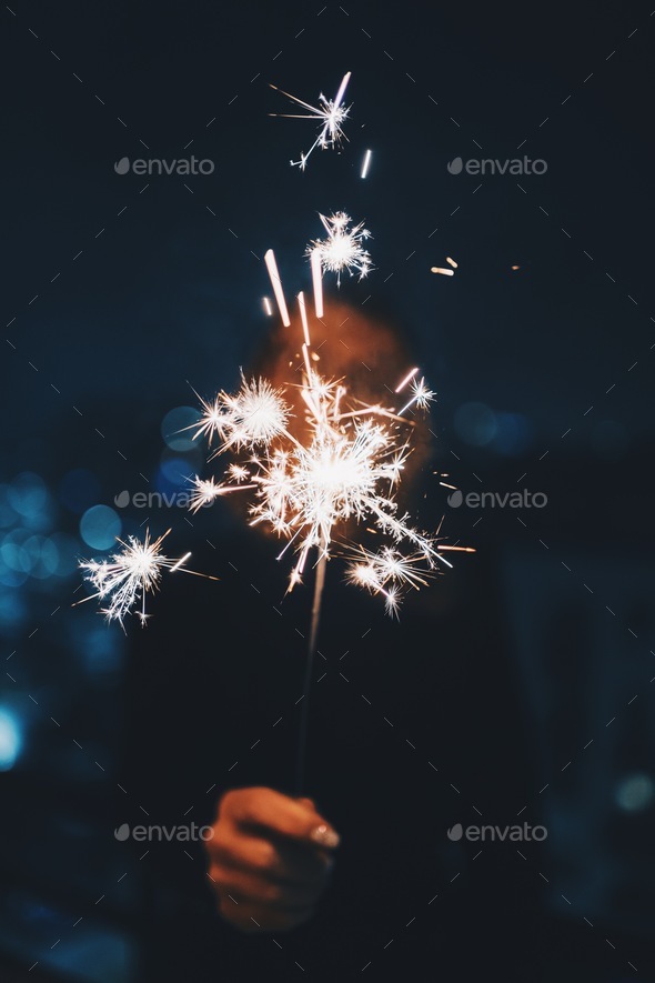 Woman’s hand holding a sparkler outside in the night Stock Photo by ...