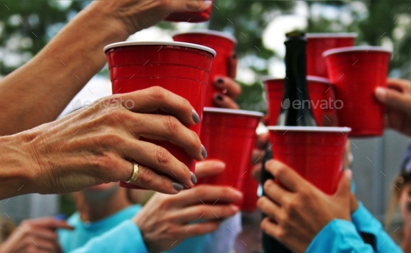 A group of friends toasting with red plastic cups outdoors Stock Photo ...