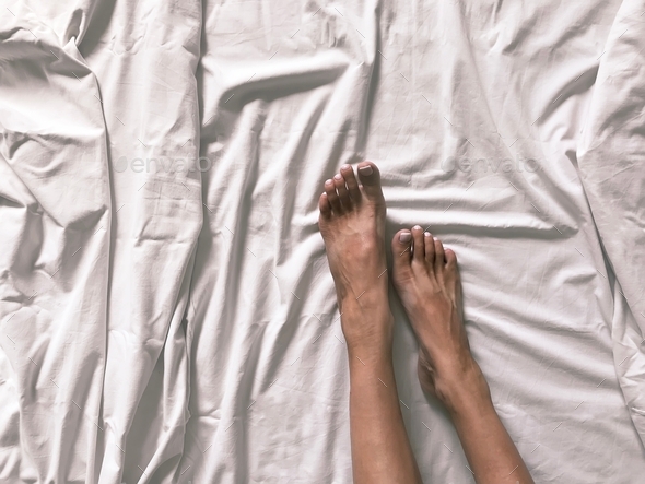 Female feet on white bed laundry Stock Photo by Leonteena | PhotoDune