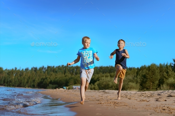Happy children running along seaside Stock Photo by uraneva | PhotoDune