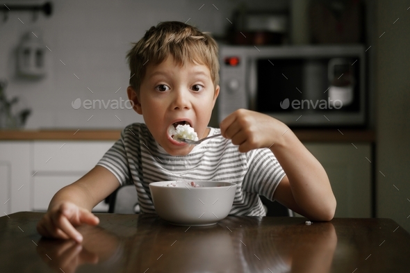 funny little boy eating his breakfast Stock Photo by uraneva | PhotoDune