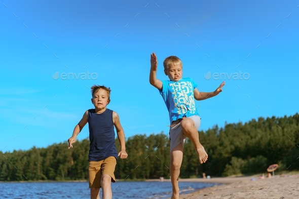 Funny little children running and jumping along sea side Stock Photo by ...