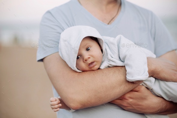 Little baby boy in strong but tender hands of his father. Carefree ...