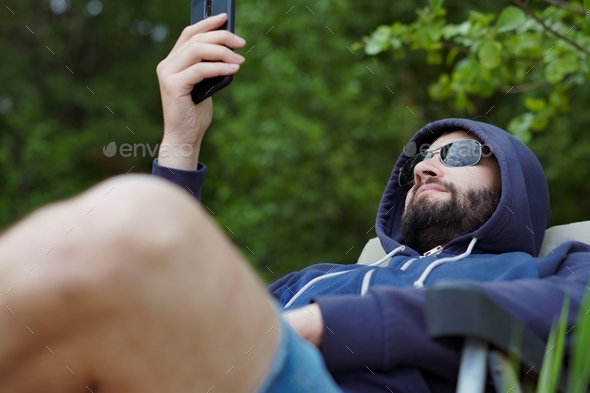 Caucasian Bearded Man Wearing Sunglasses Having Rest In Camp Chair With