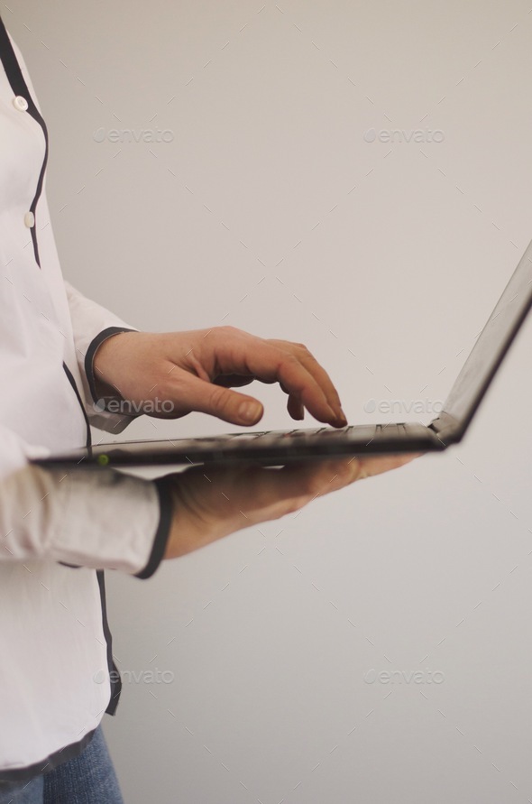 Using laptop by young woman on the white background Stock Photo by ...