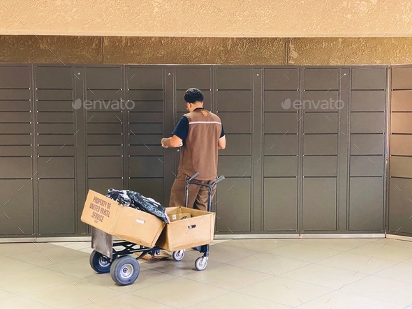 UPS delivery driver putting packages in lockers for customers to pick ...