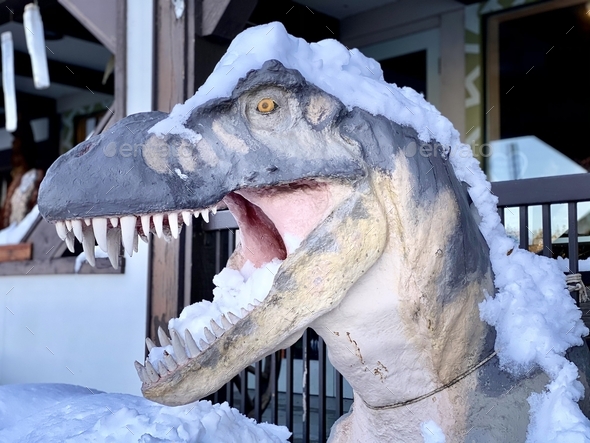 A Tyrannosaurus Rex sculpture in the snow in front of a local dinosaur ...