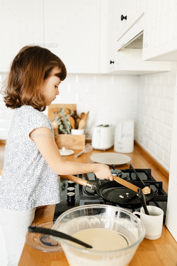 Child making pancakes for breakfast. Real people home life Stock Photo ...