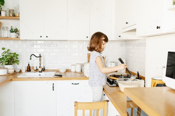 Child making pancakes for breakfast. Real people home life Stock Photo ...