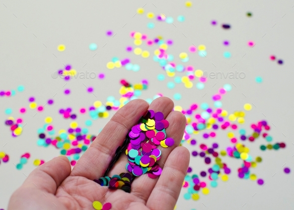 Hand holding glitter confetti ready to toss it in the air at a birthday ...