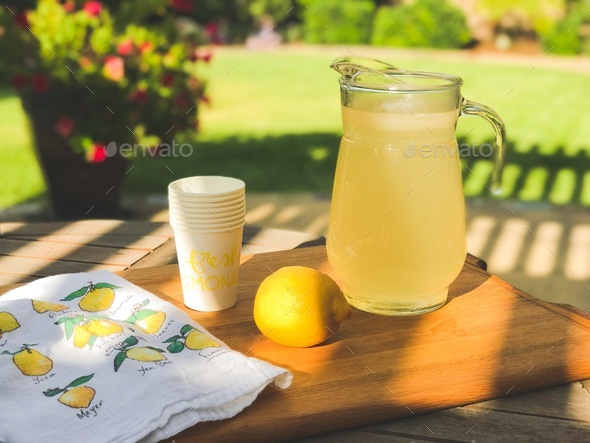 Pitcher of fresh squeezed lemonade on a patio table in the backyard on ...