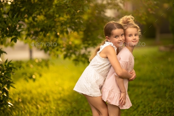 Two caucasian girls hugging each other while playing. Friendship or ...
