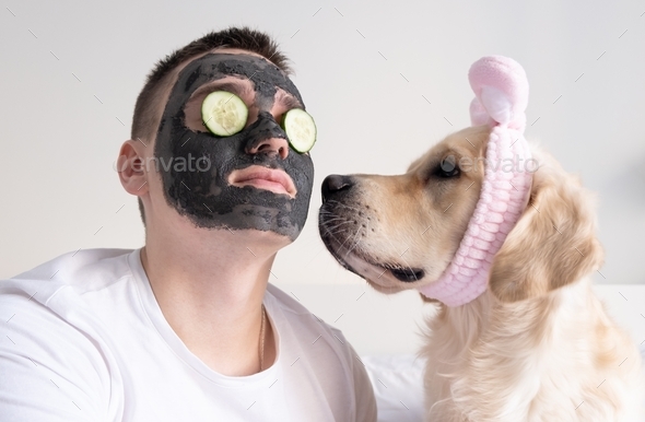 A man with a dog takes care of facial skin at home. Stock Photo by jura ...