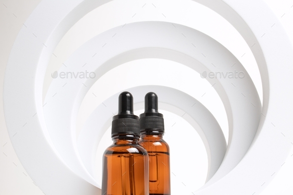 Amber glass dropper bottles different sizes on round form on white ...