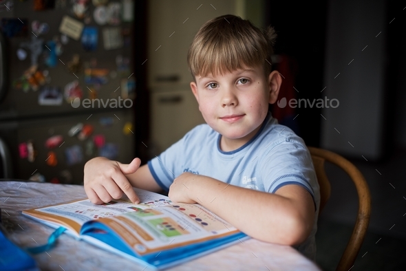 Cute little boy doing homework and reading a book Stock Photo by ...