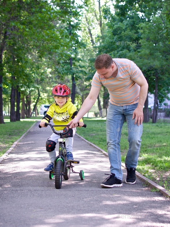 Young boy learning to ride a bike Stock Photo by Marinabars_photo