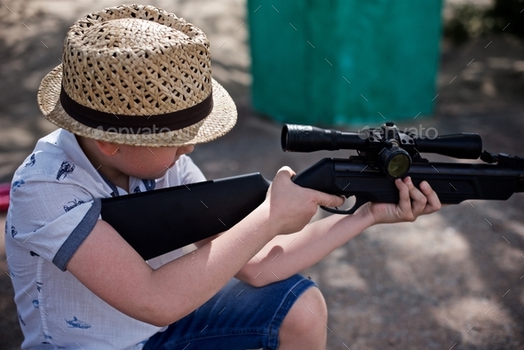 A young father teaches his son how to shoot an air rifle Stock Photo by ...