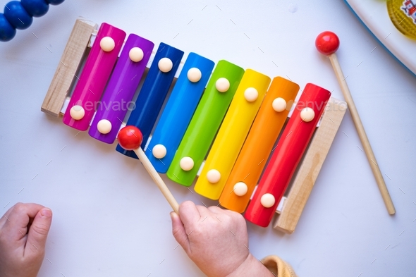 The hands of a small child playing the xylophone. Stock Photo by Banyushka