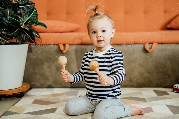 Little girl is playing with maracas. Musical development of the child ...