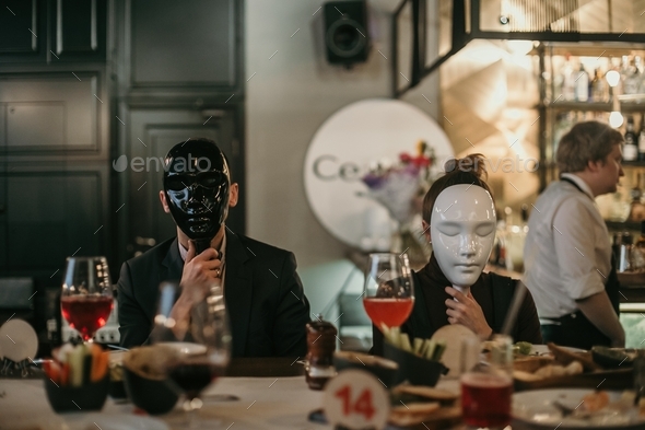 The guy and the girl put on masks on their faces in the Mafia game ...