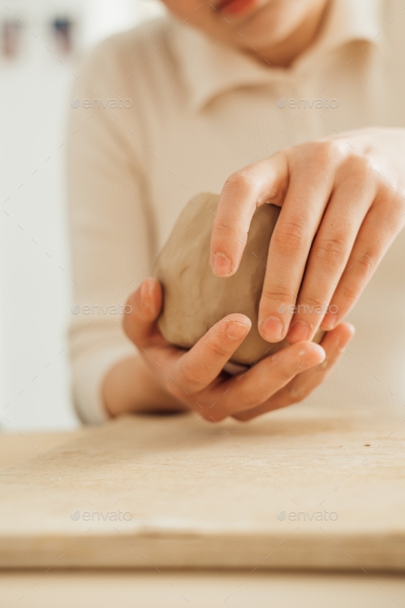 Women's hands mold a new product from clay Stock Photo by Banyushka