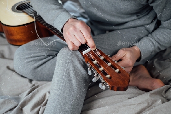 Male hands pulling a new string on an acoustic guitar Stock Photo by ...