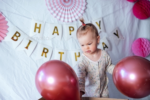 A little girl takes out balloons from a big box for her birthday Stock ...