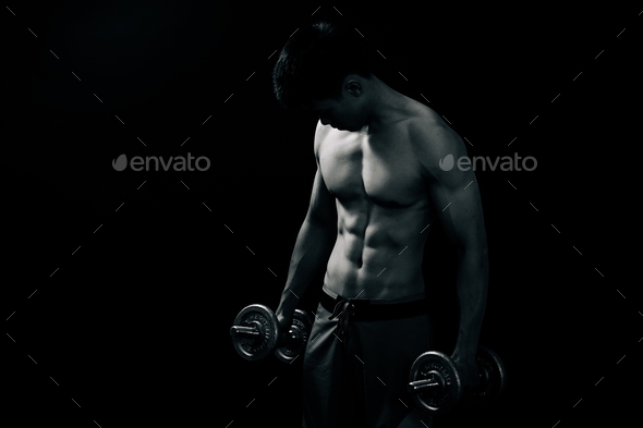 Muscular man workout in the gym. Black and white light and shadow tone ...