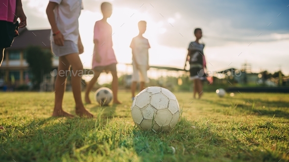 sport outdoors of a group of kids having fun playing soccer football ...