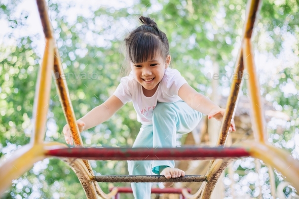 little girl playing monkey climbing at the playground Stock Photo by ...