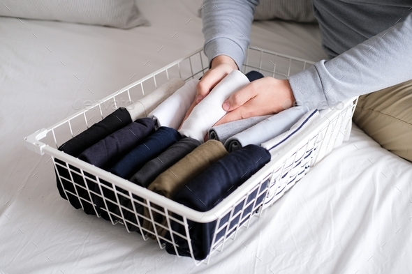 Closeup of hands of an man tidy up things in mesh storage containers ...