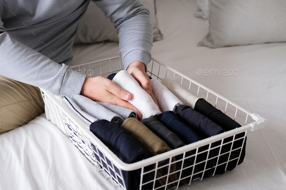 Closeup of hands of an man tidy up things in mesh storage containers ...