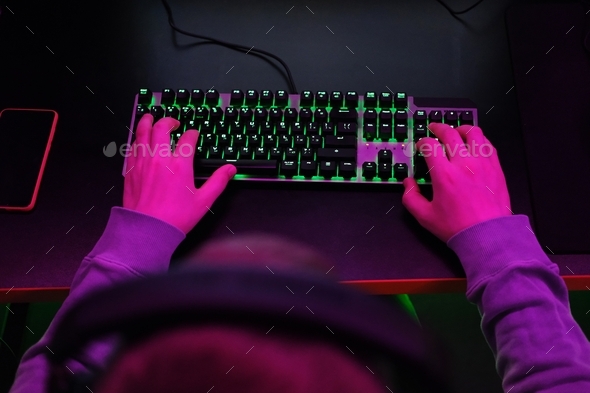 Top view of a keyboard with male hands while playing on a computer ...