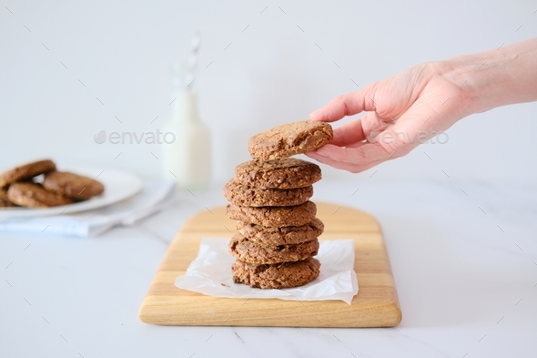 Woman's hand holding a cookie from a stack freshly baked Stock Photo by ...
