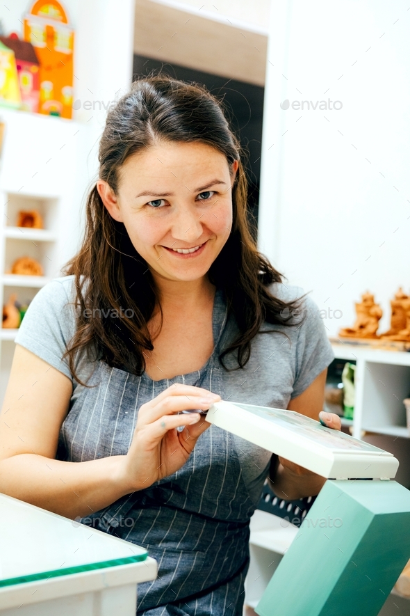 Woman Artist craftsman works in creative workshop and decorates box ...