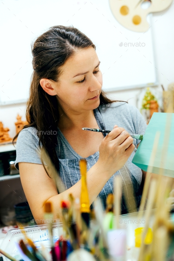 Woman Artist craftsman works in creative workshop and decorates box ...