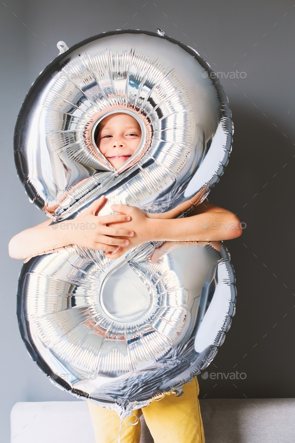 Happy boy Gen z kid with silver balloon number 8 on his birthday party ...
