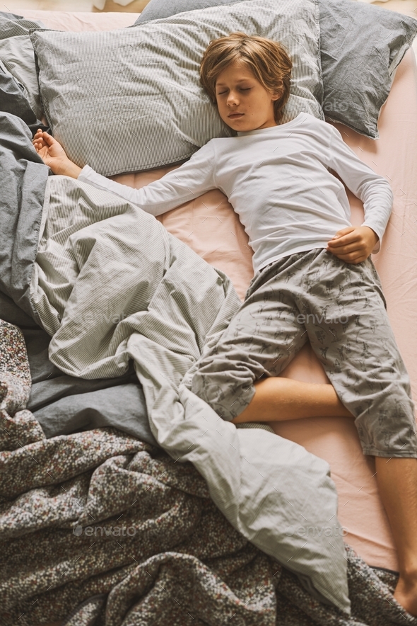 Cute 10 years old boy in sleeping time. Top view Stock Photo by olgapink