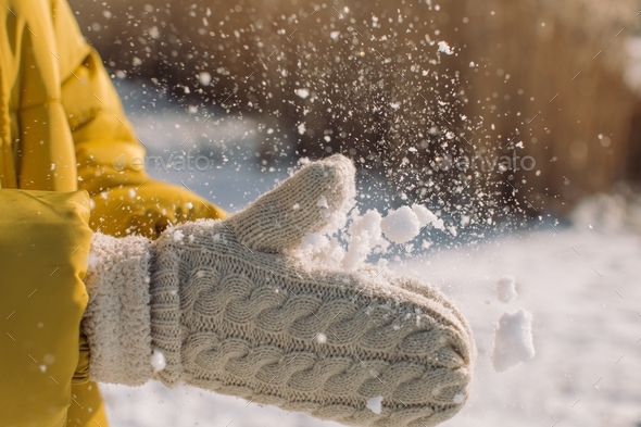 Young girl in mittens throwing snowball and clapping hands. Sunny ...