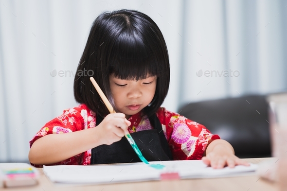 Smart little Asian girl having an idea make art as a hobby while at ...