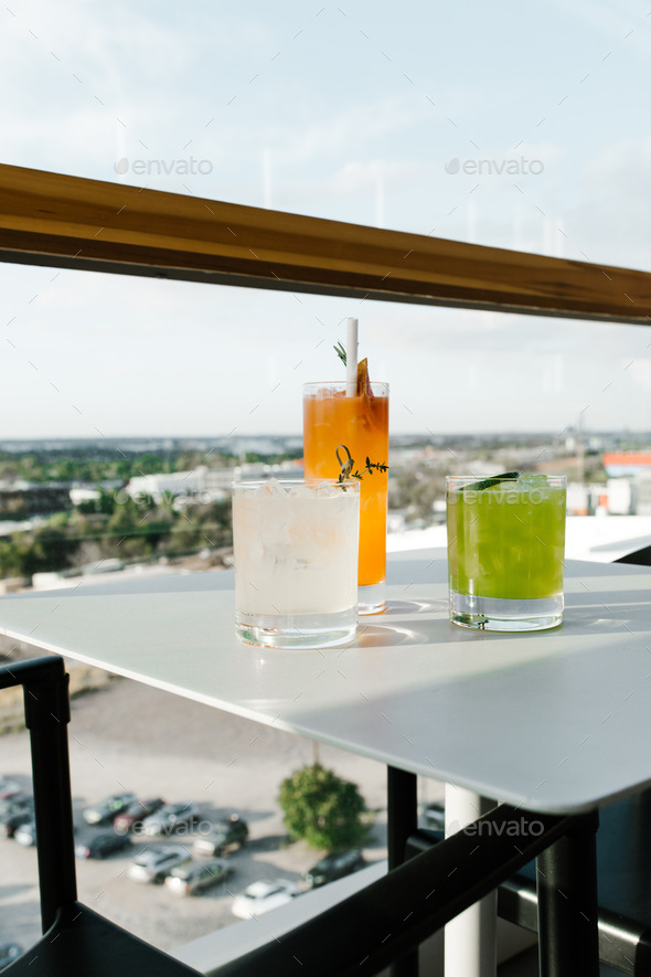 Colorful orange and green cocktails on a rooftop bar patio Stock Photo ...