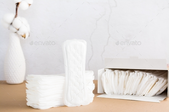 Clean disposable sanitary pads in a stack and in a box and a branch of ...