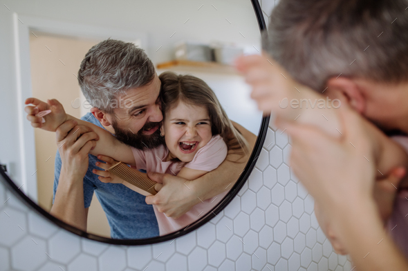 Father brushing his little daughter's hair in bathroom, morning routine concept. Stock Photo by ...