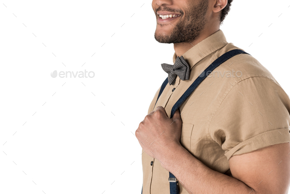 Cropped shot of smiling young man in suspenders and bow tie posing ...