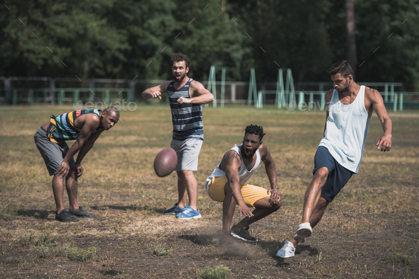 group of young multicultural men playing football on court Stock Photo ...