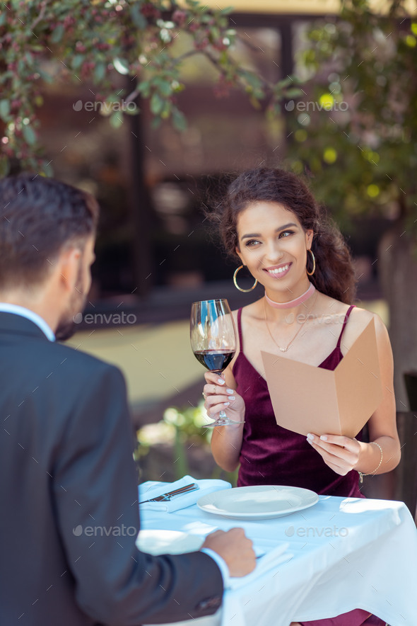 Couple having romantic date in restaurant, woman choosing meal in menu ...